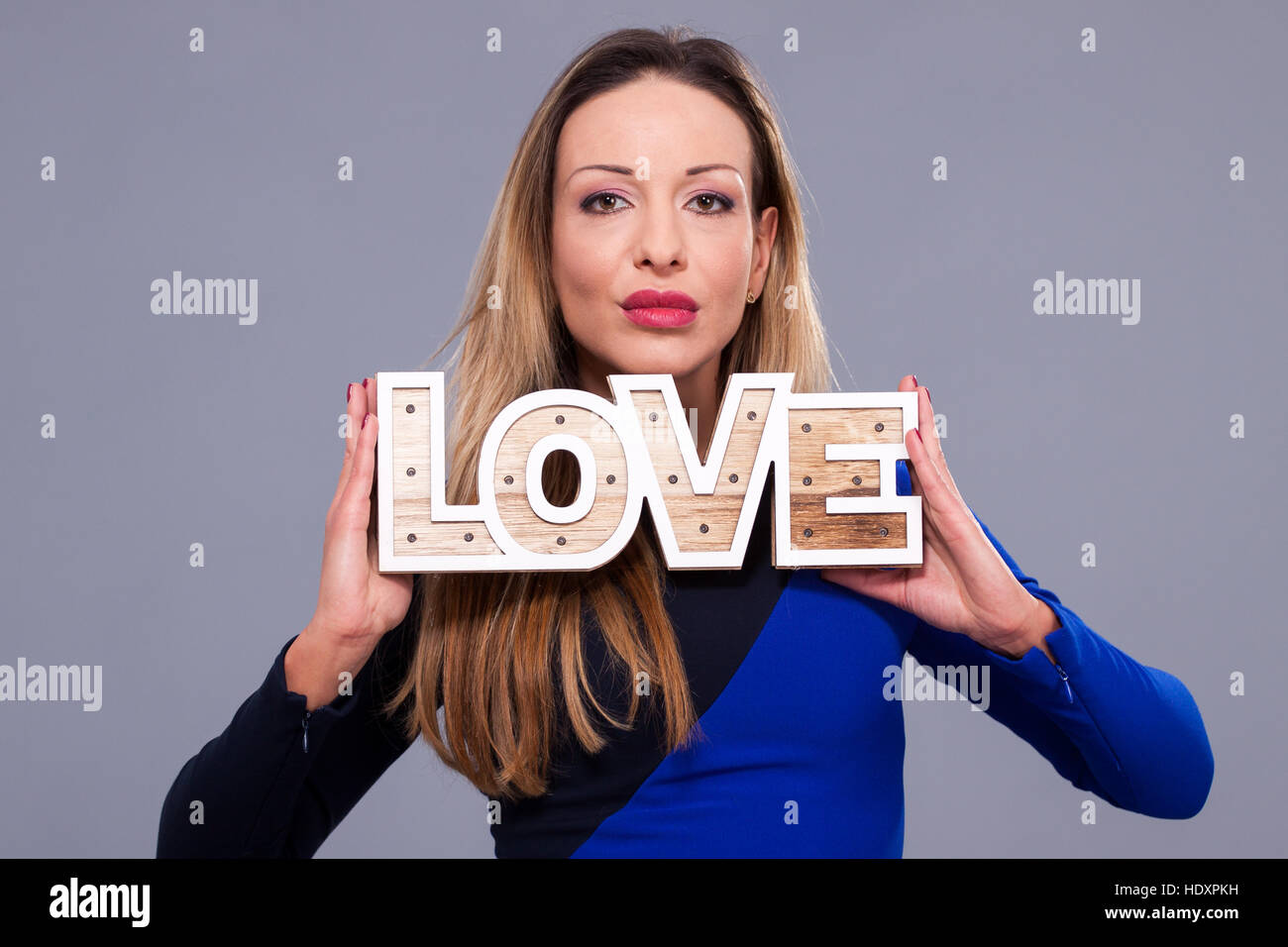 Valentines Day. Woman wearing blue dress holding sign love symbol on ...
