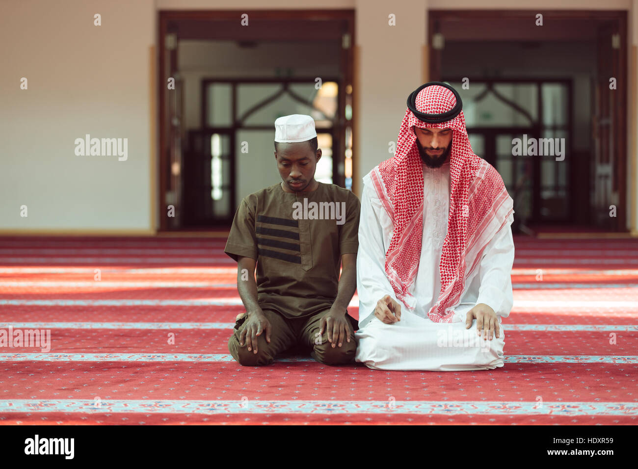 Two religious muslim man praying together inside the mosque Stock Photo ...