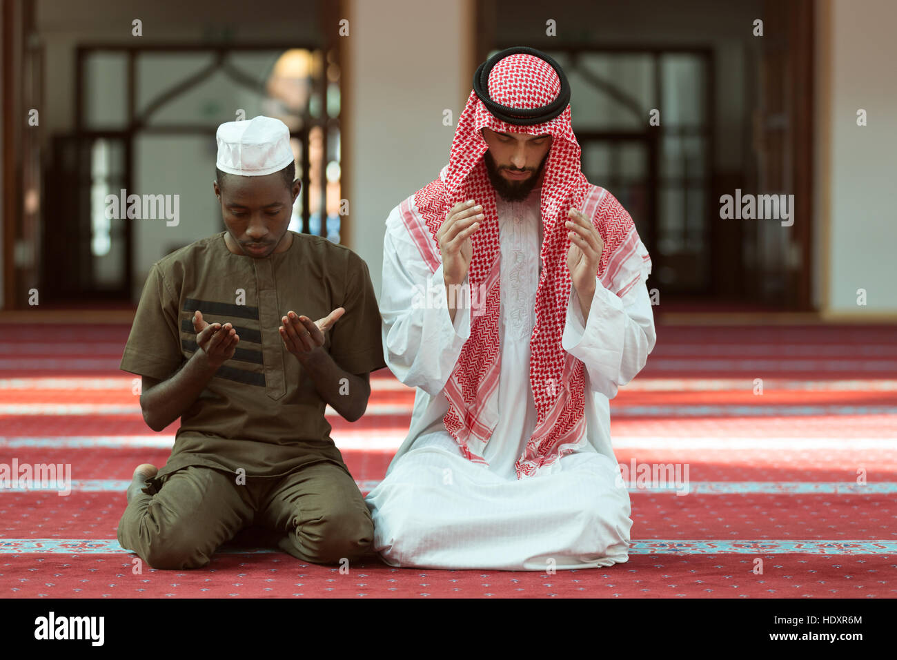 Two religious muslim man praying together inside the mosque Stock Photo ...