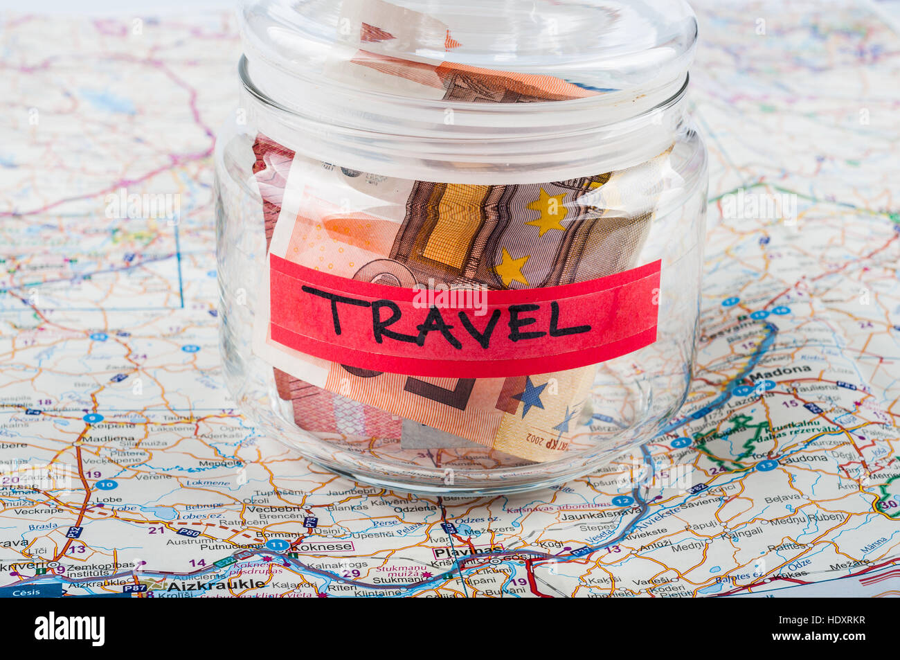 Savings jar for travel on a map Stock Photo - Alamy