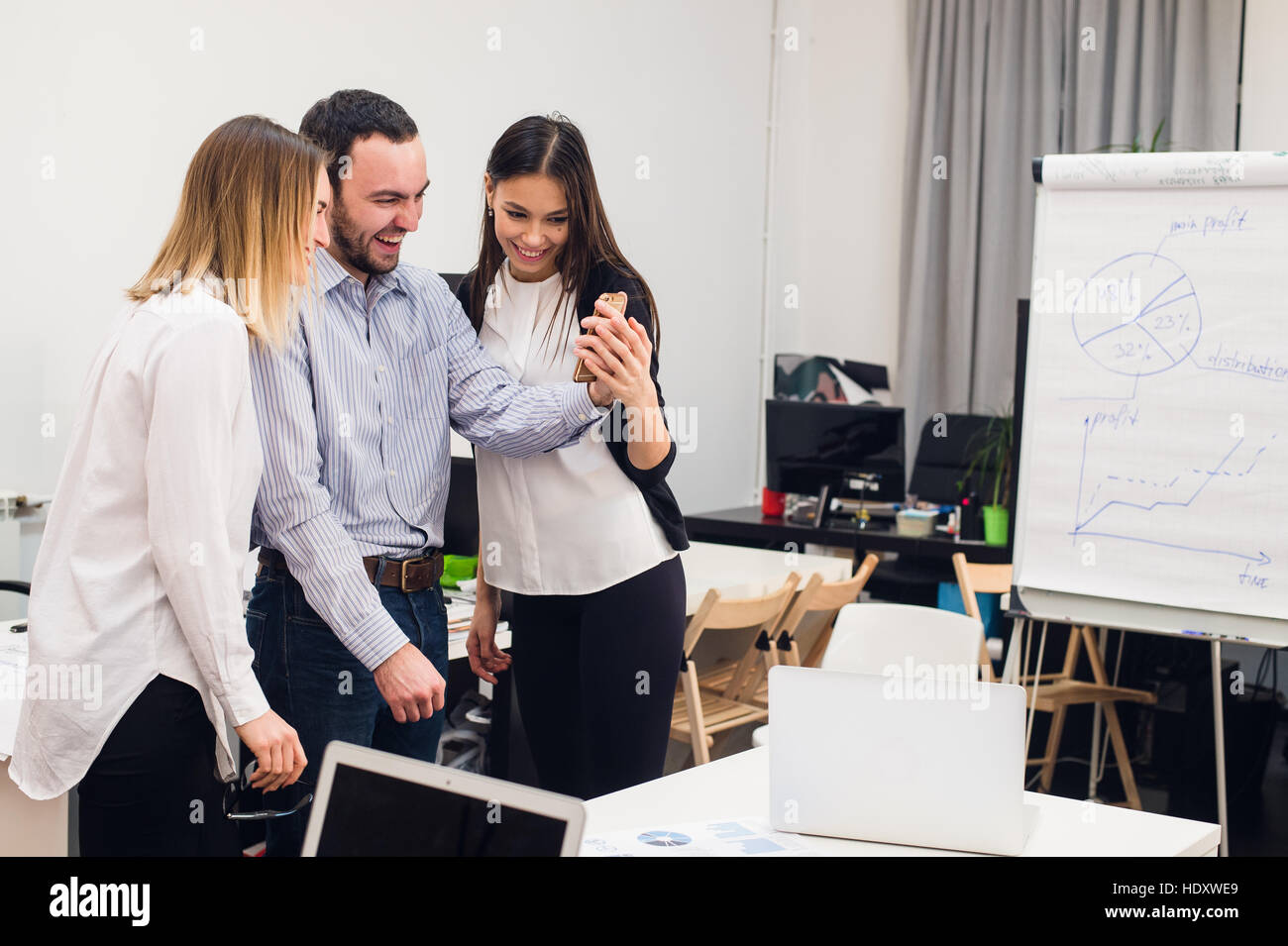 Group of four diverse cheerful co-workers taking self portrait and ...