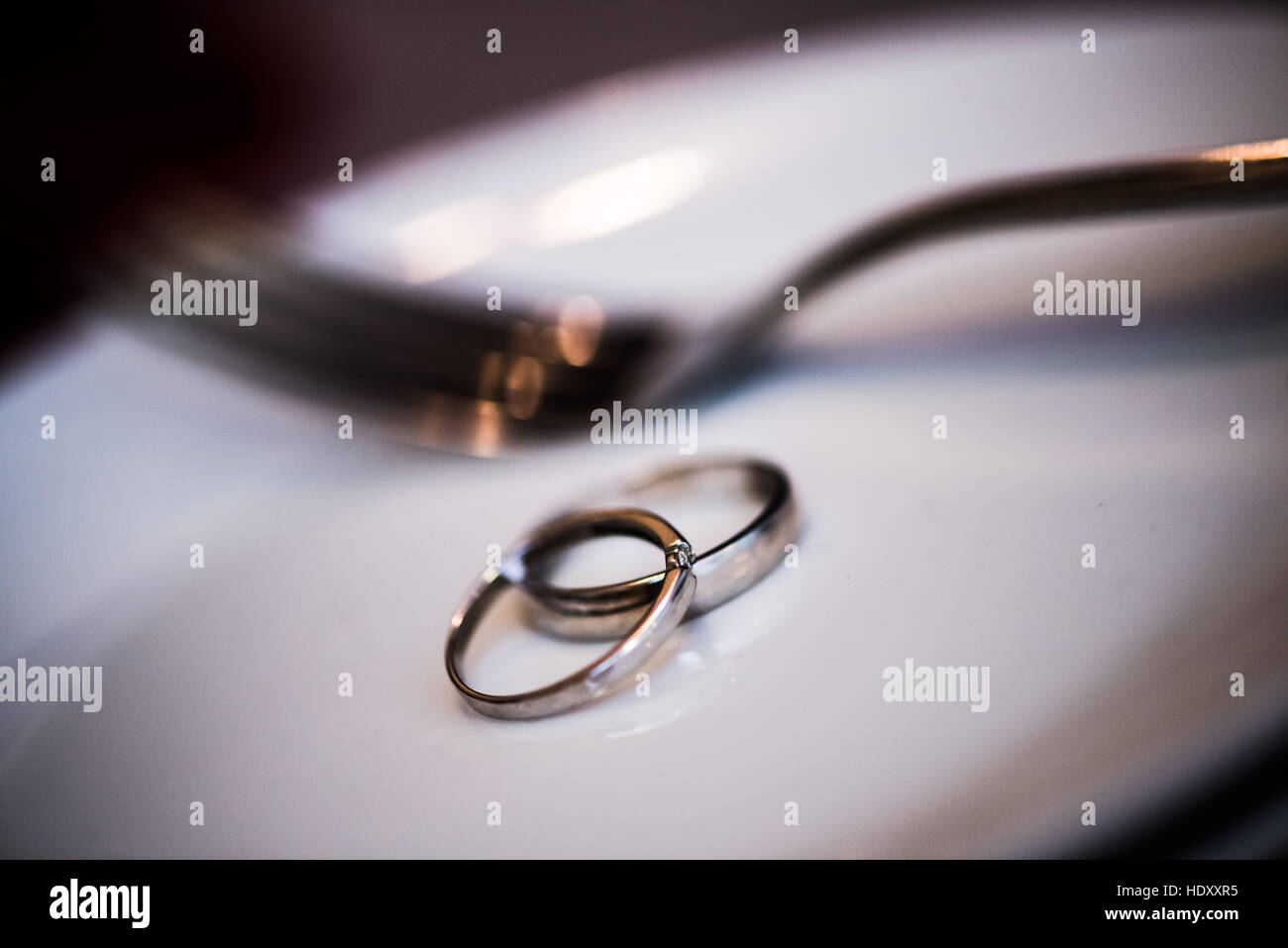 wedding rings on plate with fork Stock Photo - Alamy