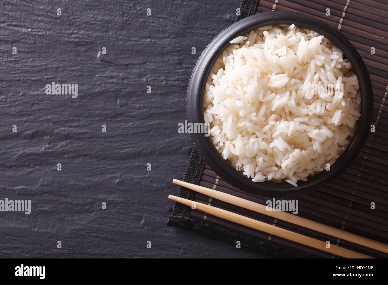 Japanese food: rice in a black bowl and chopsticks. horizontal view ...