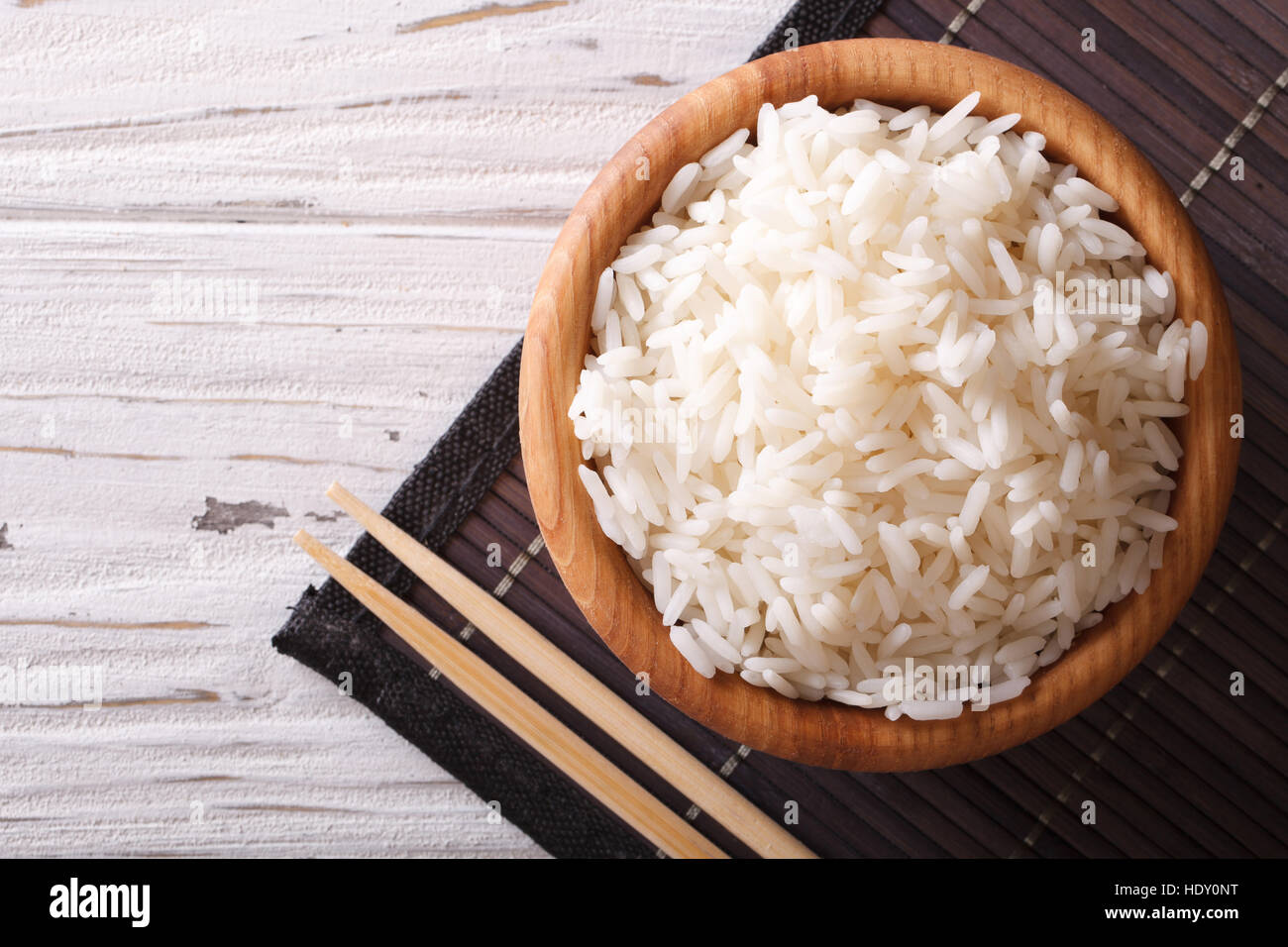 Japanese food: steamed rice in a wooden bowl and chopsticks. horizontal ...
