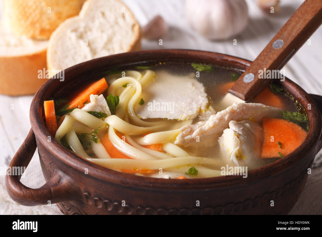 Homemade chicken soup with noodles and vegetables close-up. horizontal ...