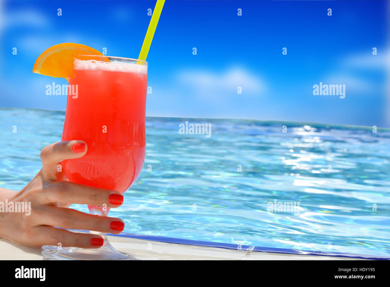 Hand holding a cocktail near a swimming pool Stock Photo - Alamy