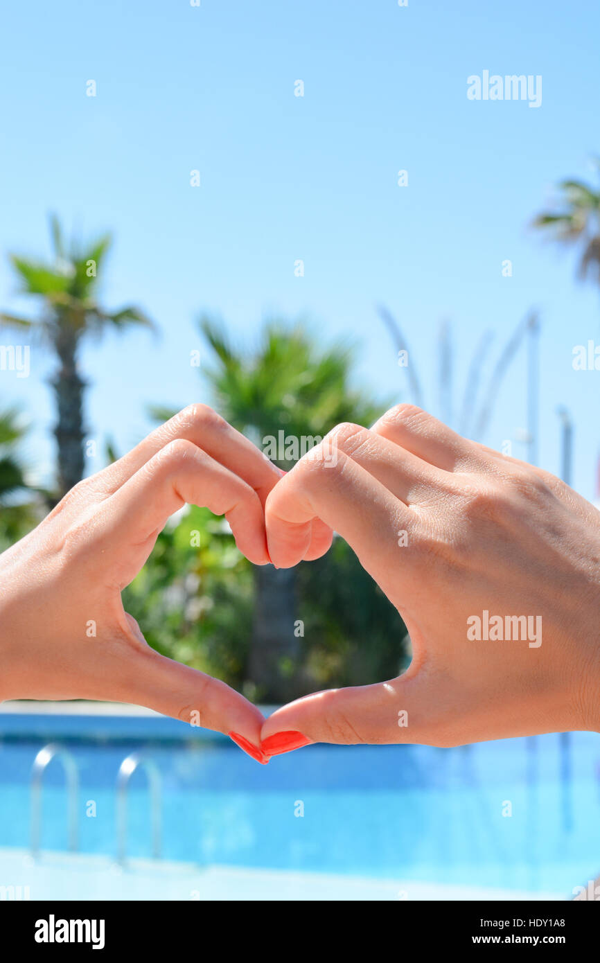 Heart shaped hands with a pool and palm trees in the background Stock ...
