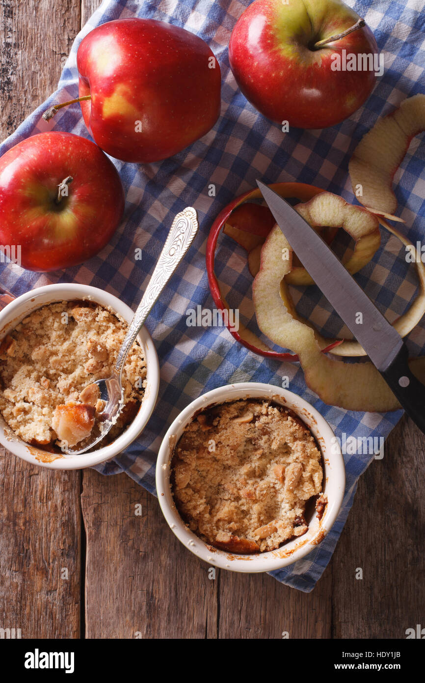 apple crumble in pots for baking on the table. vertical top view of ...