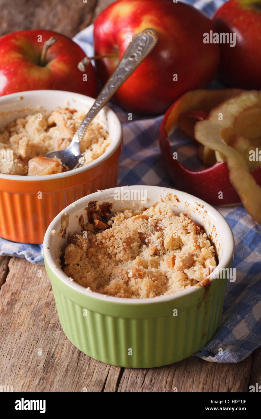 English crumble with apples close-up in the pot. vertical rustic style ...