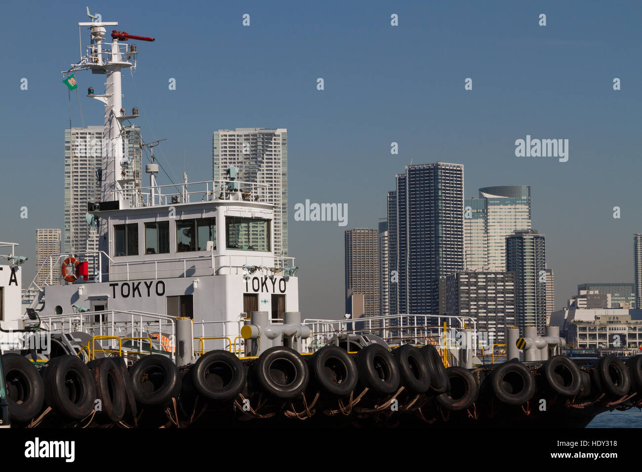 Tug boats in Tokyo Bay, with high-rise apartment buildings behind ...