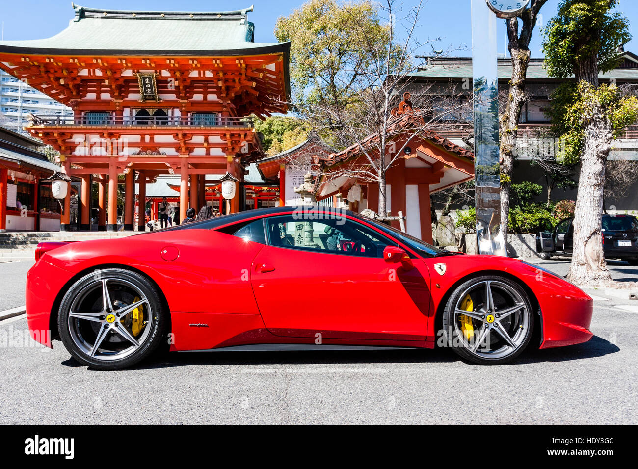 Red Ferrari 458 Italia parked near vermillion two-storey Romon gate of ...