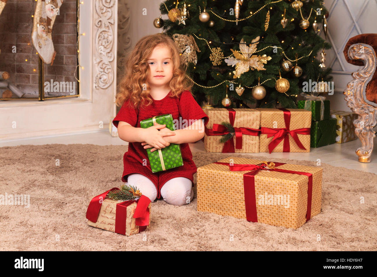 little girl in red dress opens New Year gift,holiday, Christmas 2017, Christmas, joy, happiness ...