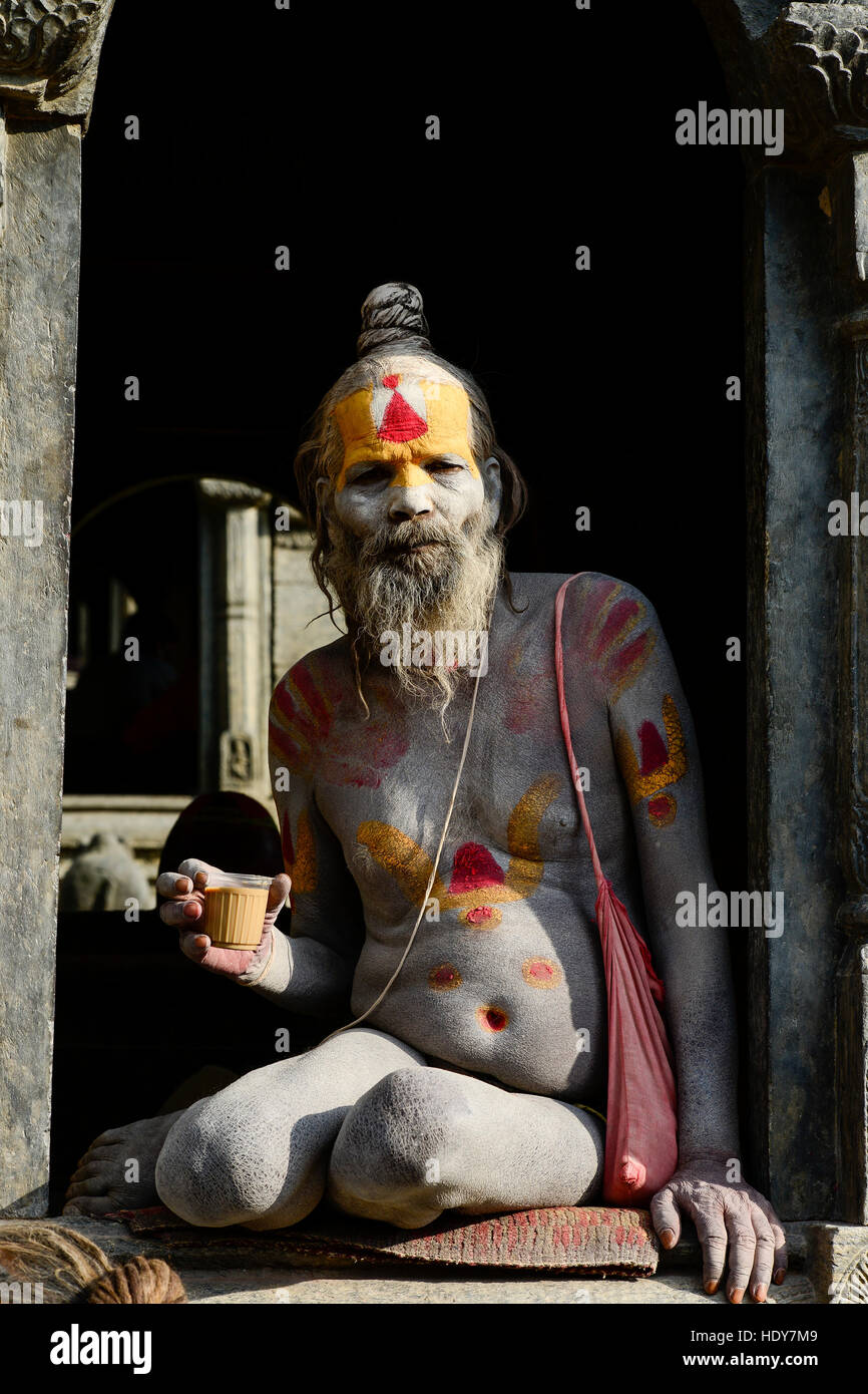 NEPAL Kathmandu, Pashupatinath Hindu Temple, ash saearded sadhu drinks ...