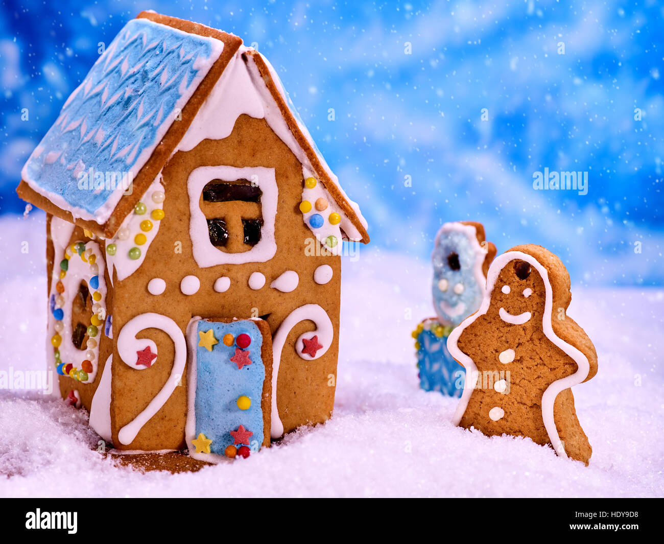 Christmas gingerbread man and house in snow on blue background Stock ...