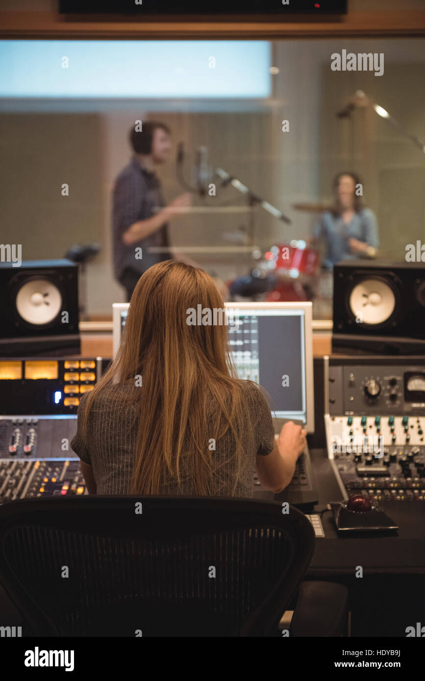 Rear view of audio engineer using sound mixer in recording studio Stock ...