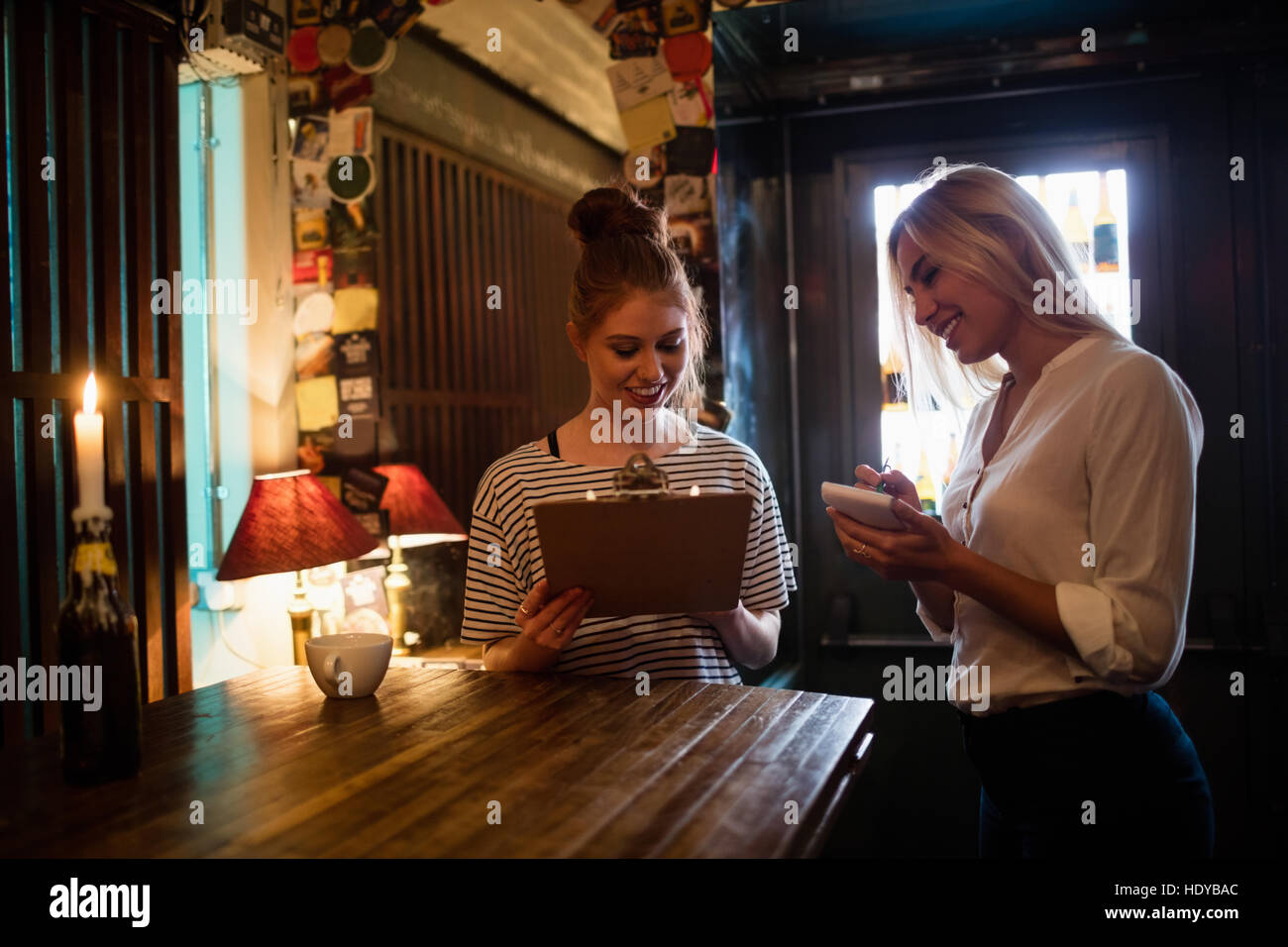 Waitress discussing the menu with the customer in the bar Stock Photo ...