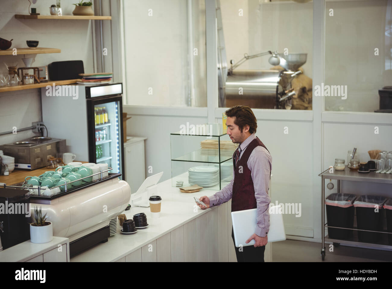Man using mobile phone in coffee shop Stock Photo - Alamy