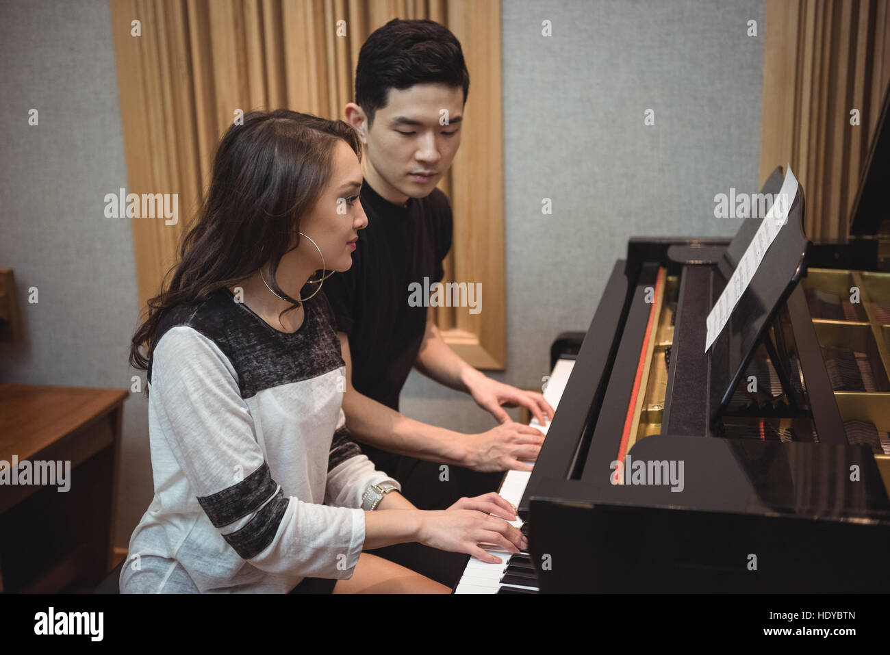 Couple playing a piano in recording studio Stock Photo - Alamy