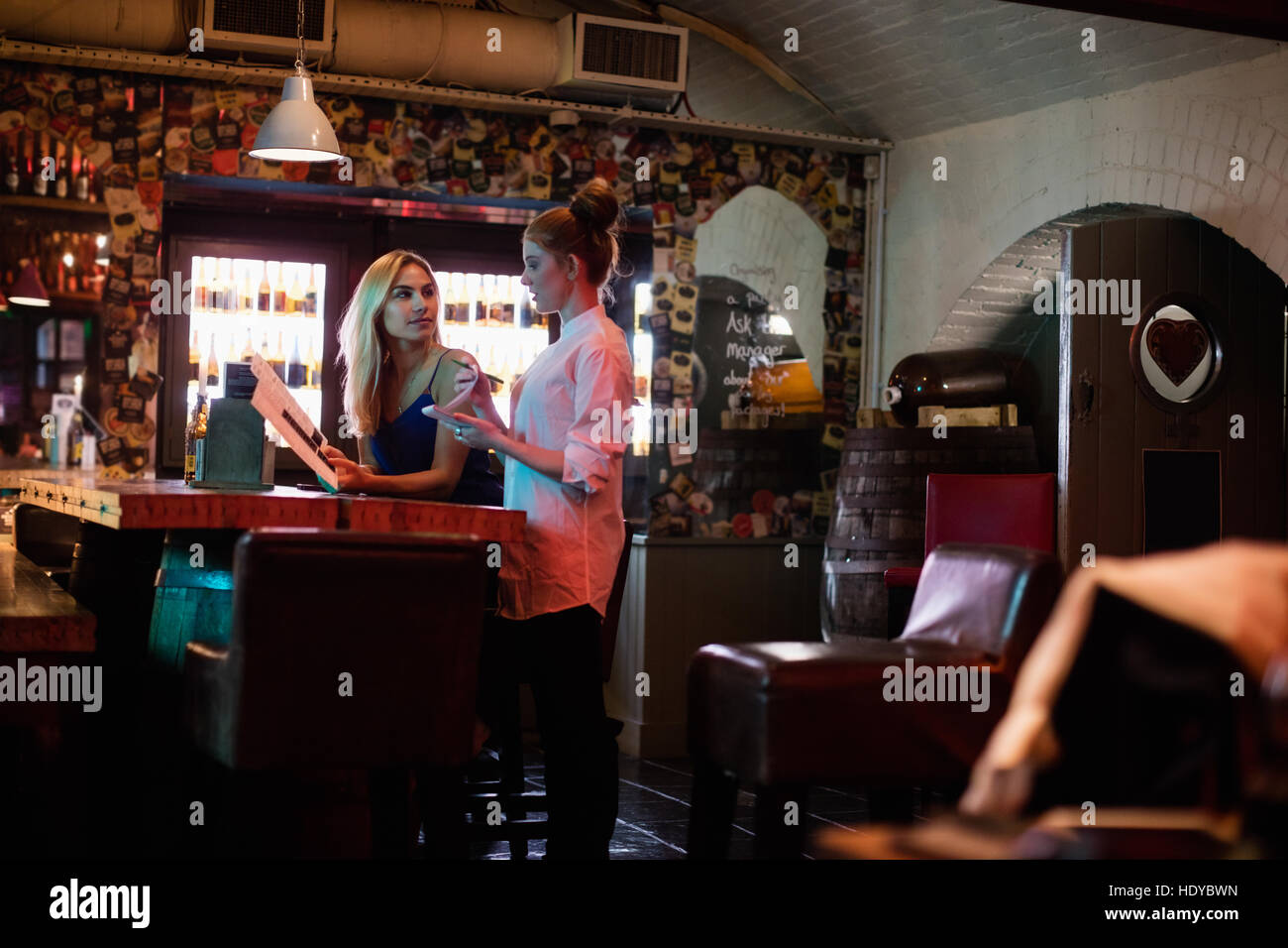 Waitress discussing the menu with the customer in the bar Stock Photo ...