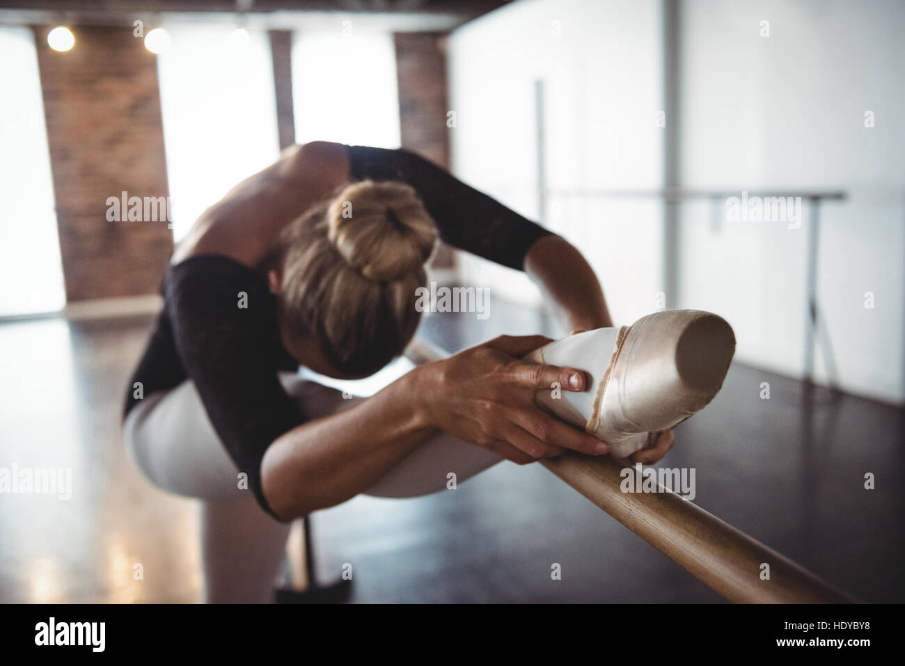 Ballerina stretching at barre in ballet studio Stock Photo - Alamy