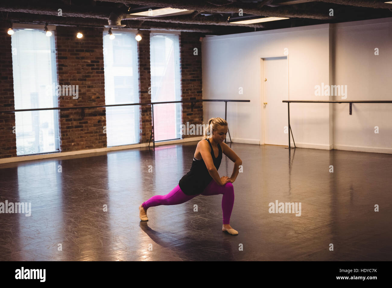 Woman performing stretching exercise in dance studio Stock Photo - Alamy