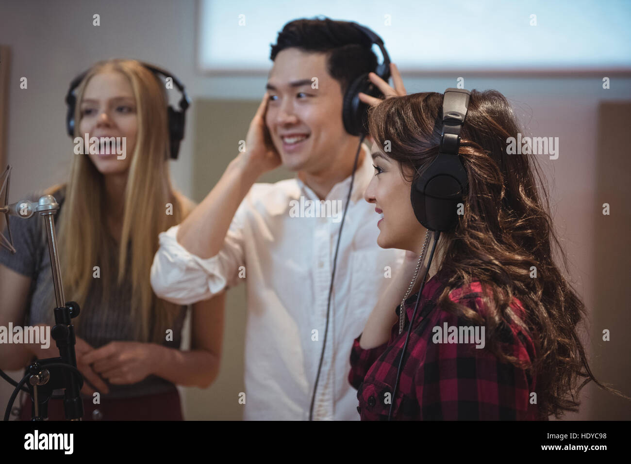 Singers performing in recording studio Stock Photo - Alamy