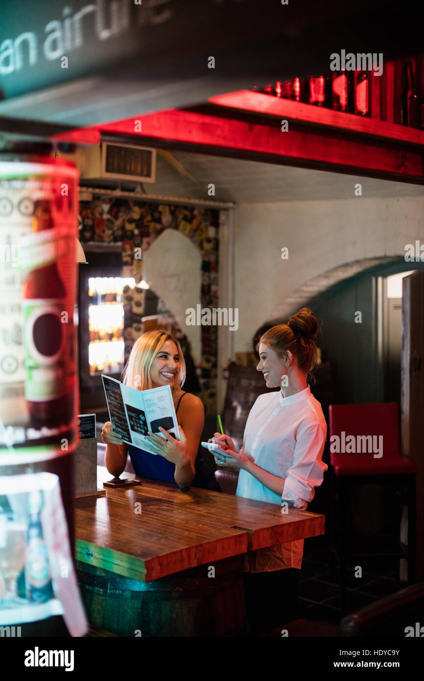 Waitress discussing the menu with the customer in the bar Stock Photo ...