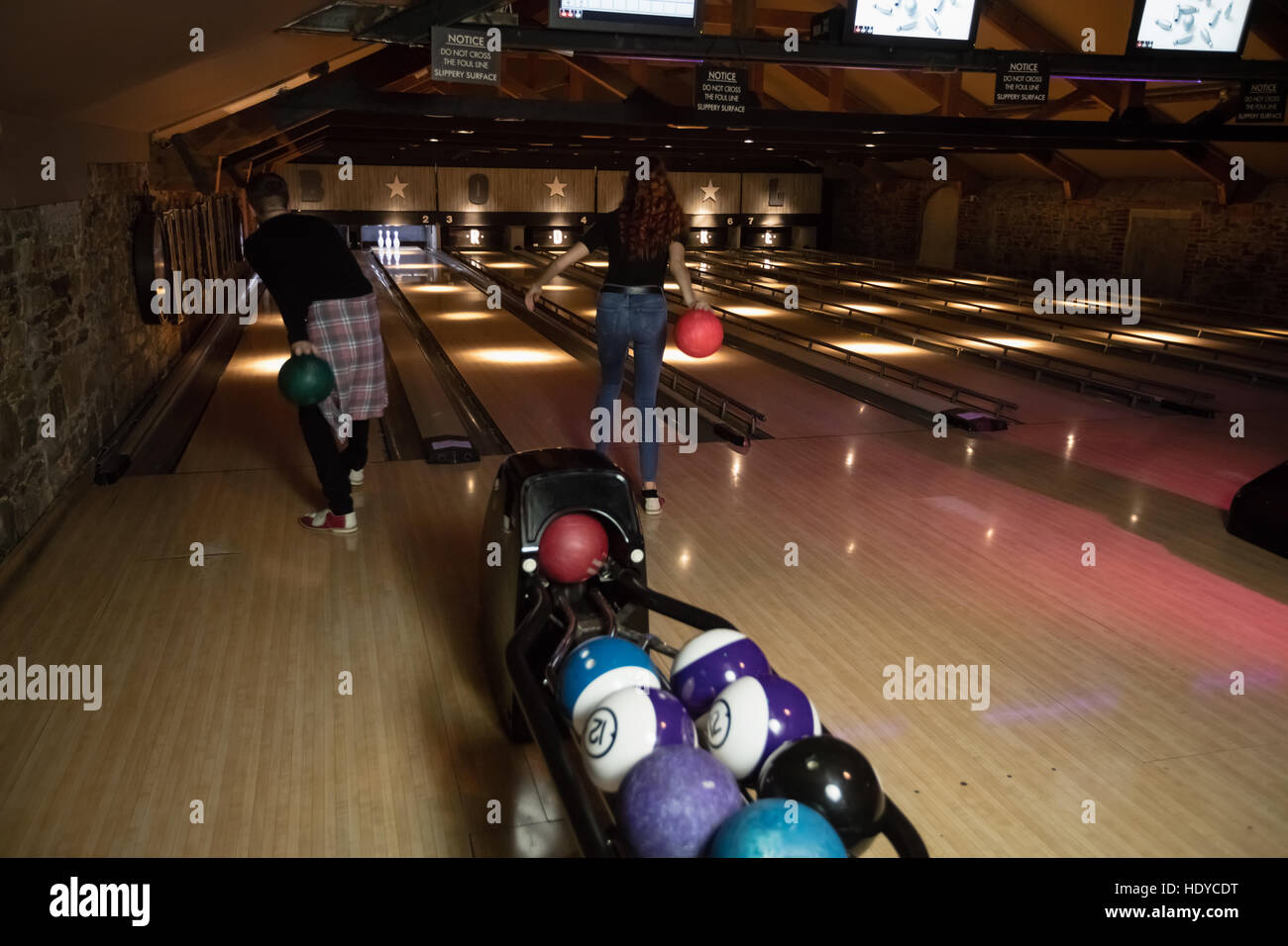 Rear view of two young people bowling at bowling alley Stock Photo - Alamy