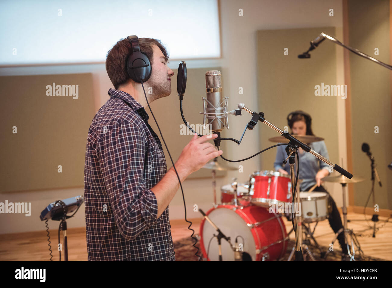 Man singing on microphone in recording studio Stock Photo - Alamy