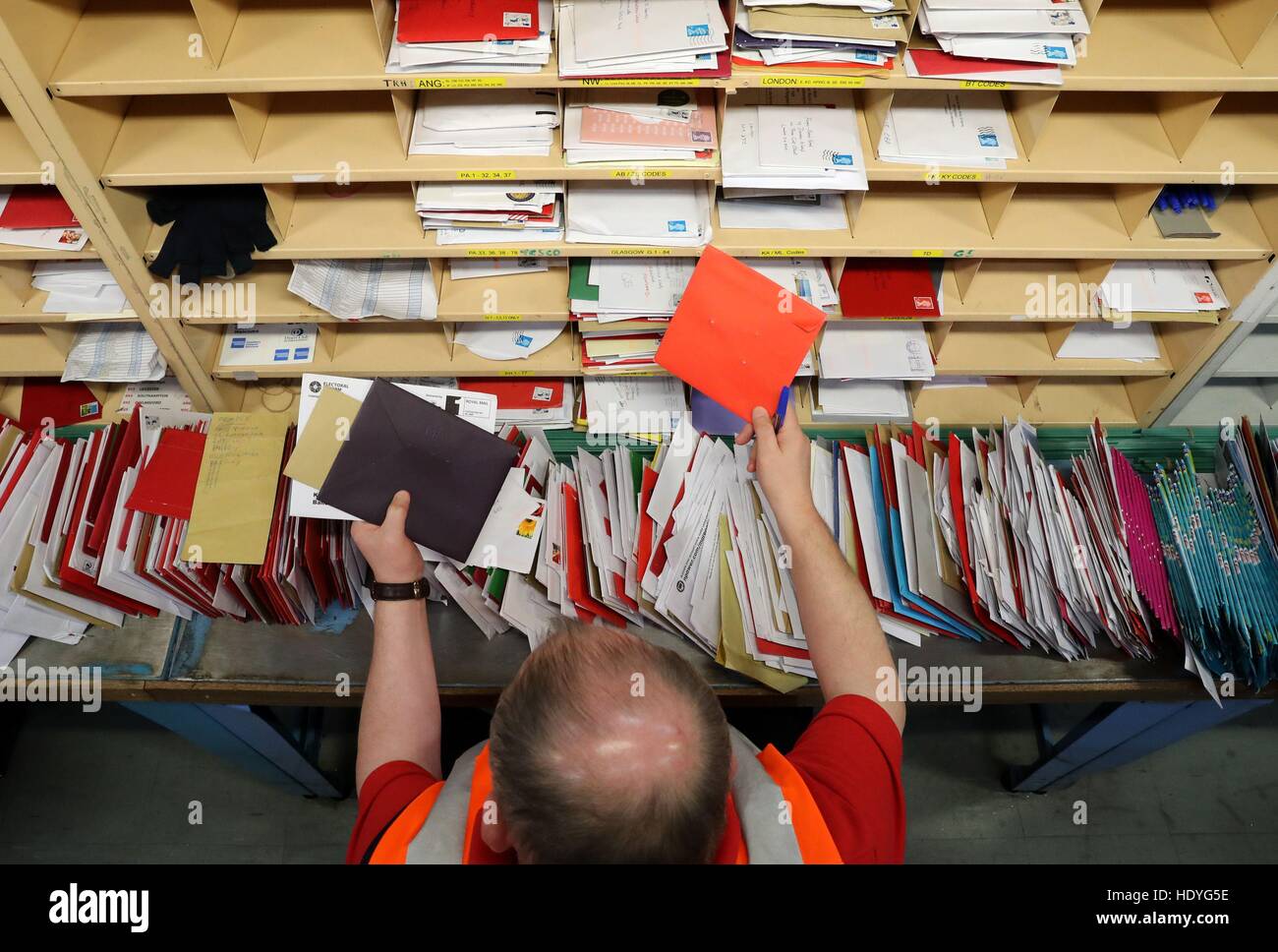 A Royal Mail worker sorts mail at the Royal Mail's Sorting Office in ...