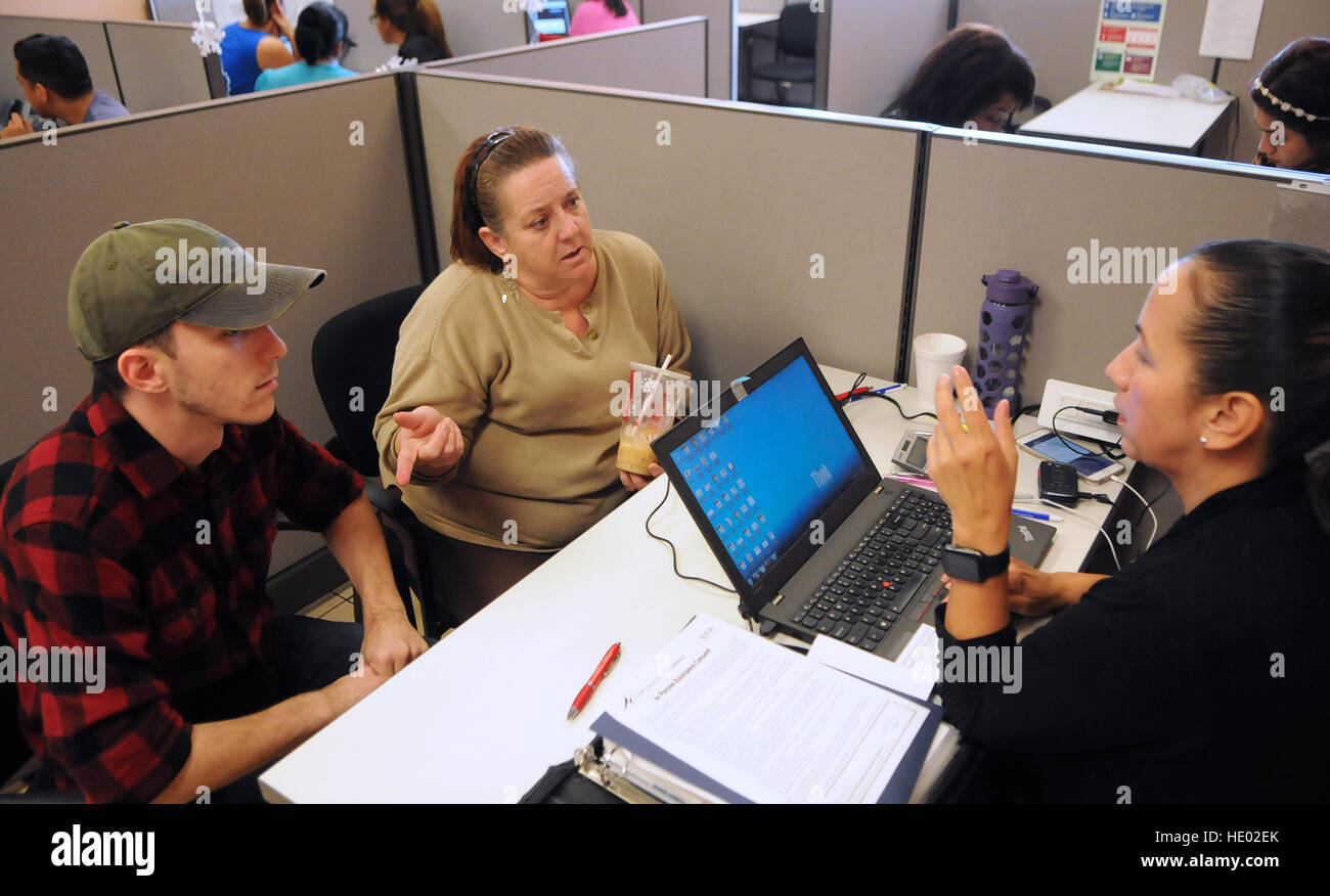 Orlando, Florida, USA. 15th Dec, 2016. An enrollment assistant helps a ...