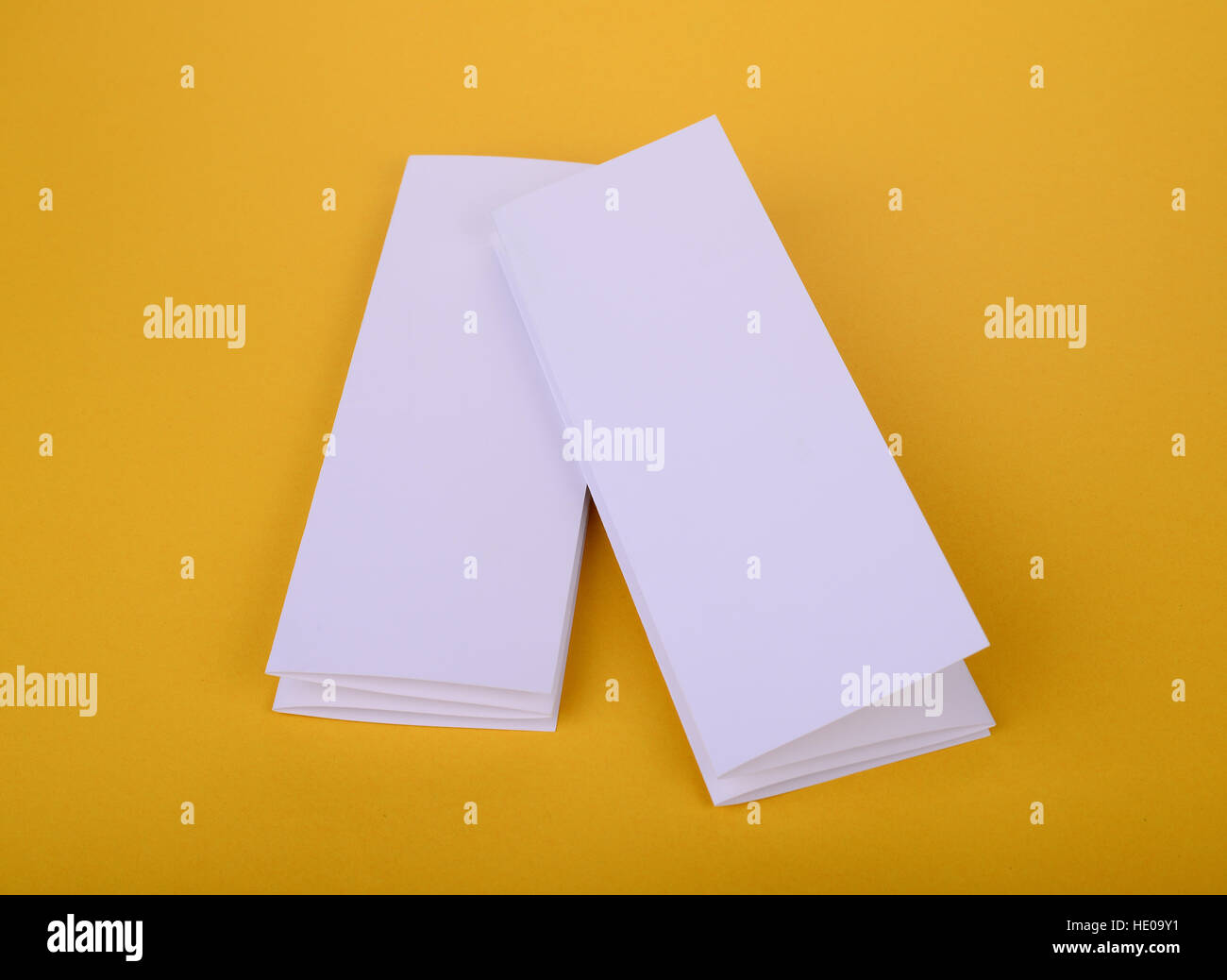 two white paper four-fold brochure mockup on yellow background Stock ...