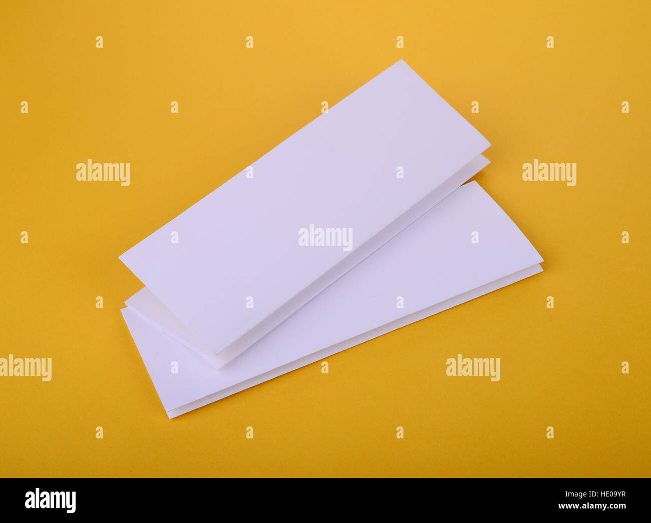 two white paper four-fold brochure mockup on yellow background Stock ...