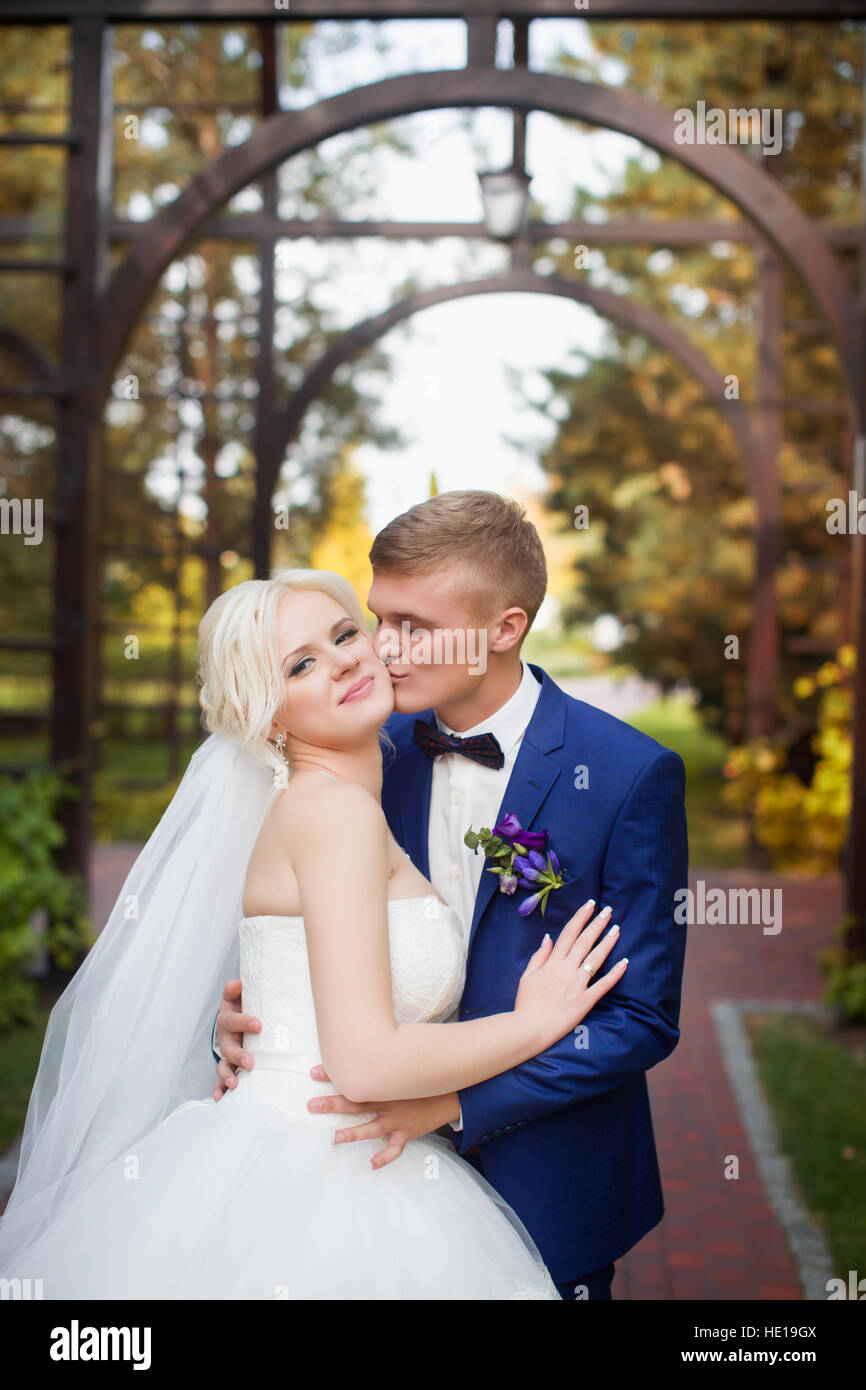 The groom gently hug the bride's shoulders Stock Photo - Alamy