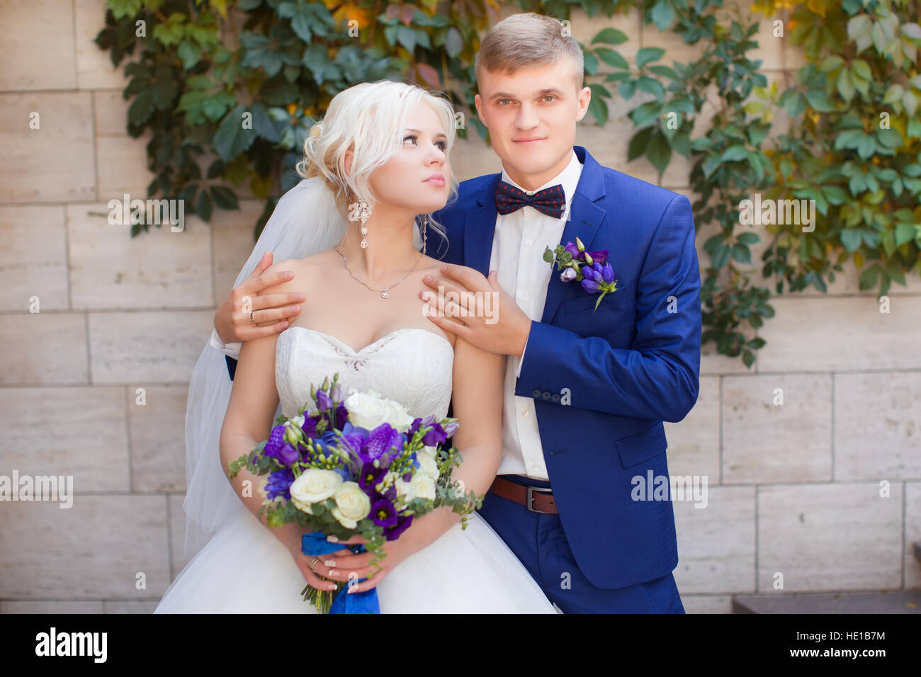 The groom gently hug the bride's shoulders Stock Photo - Alamy