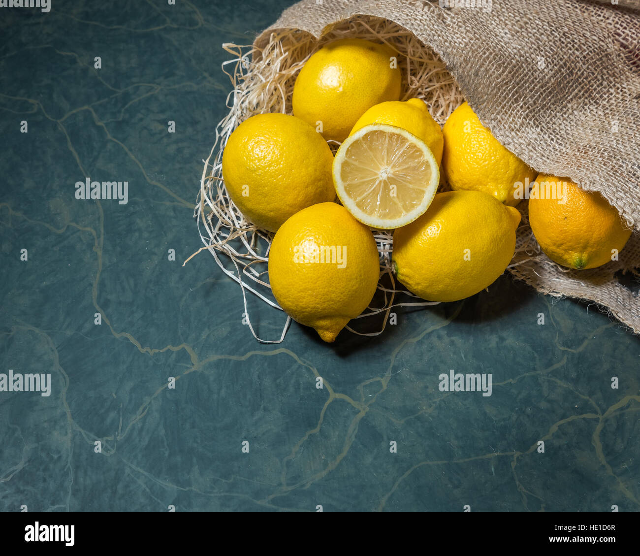 Fresh picked lemons spilling from a burlap sack. Horizontal format with ...