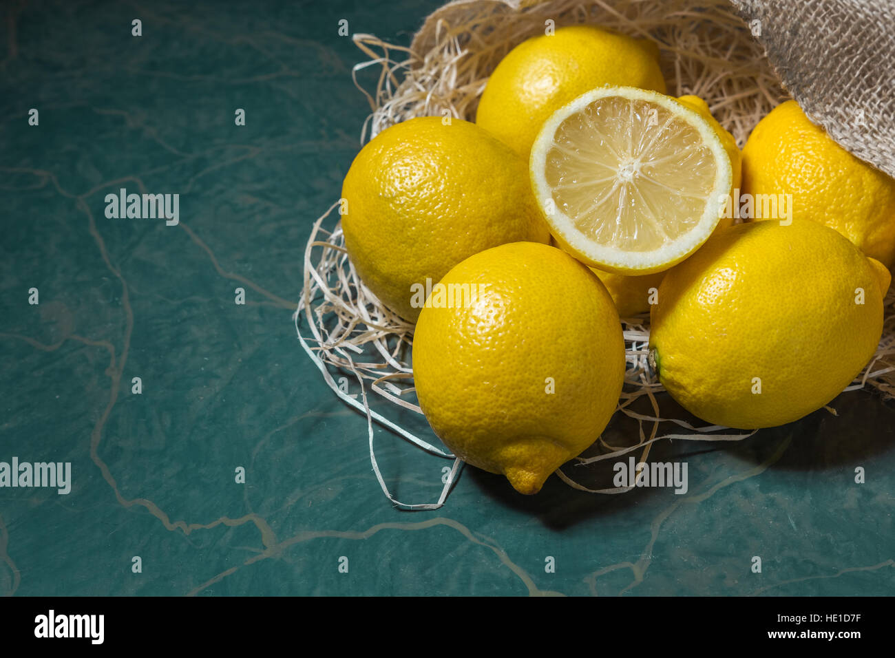 Fresh picked lemons spilling from a burlap sack close up. Horizontal ...