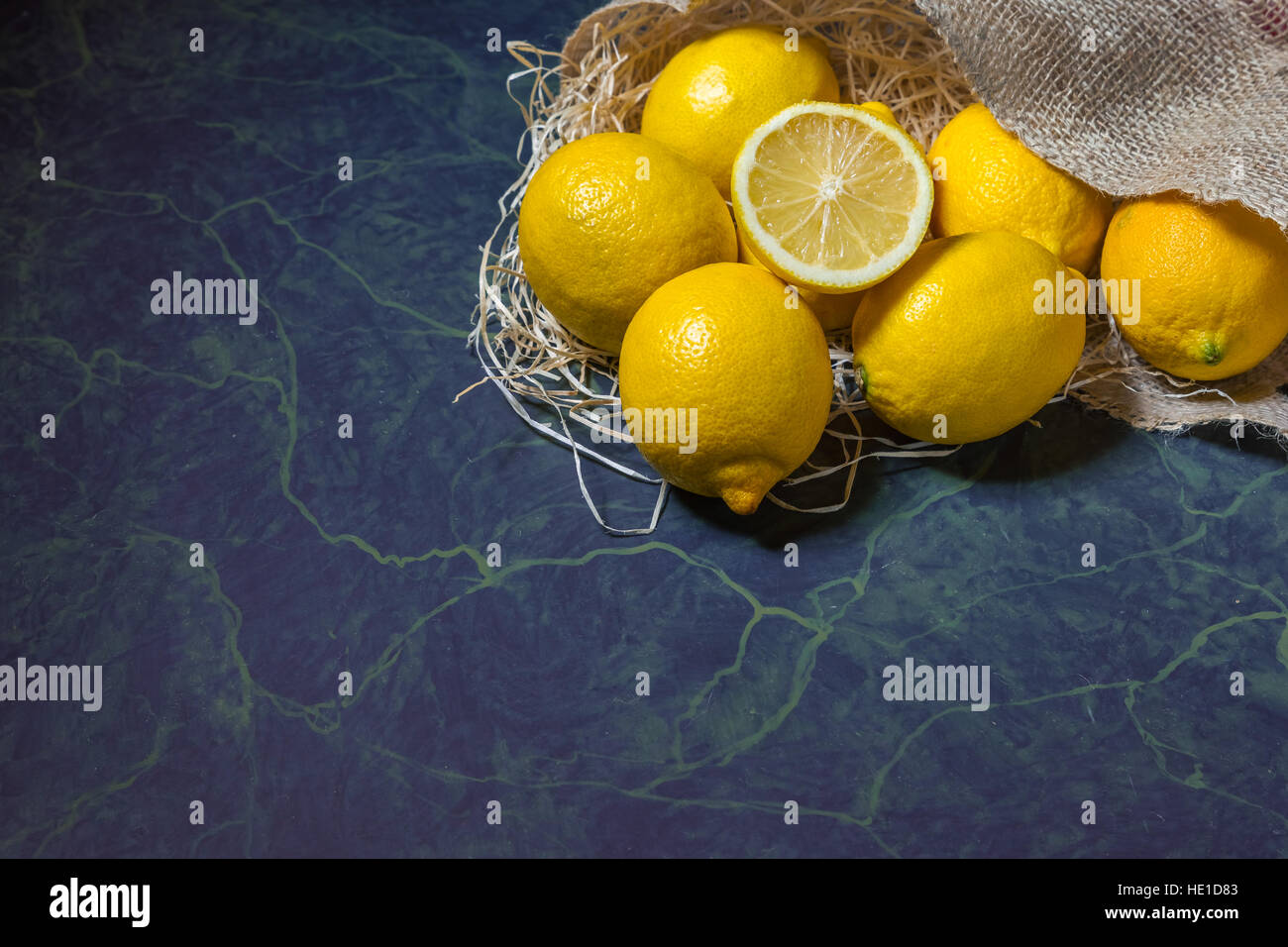 Fresh picked lemons spilling from a burlap sack. Horizontal format with ...
