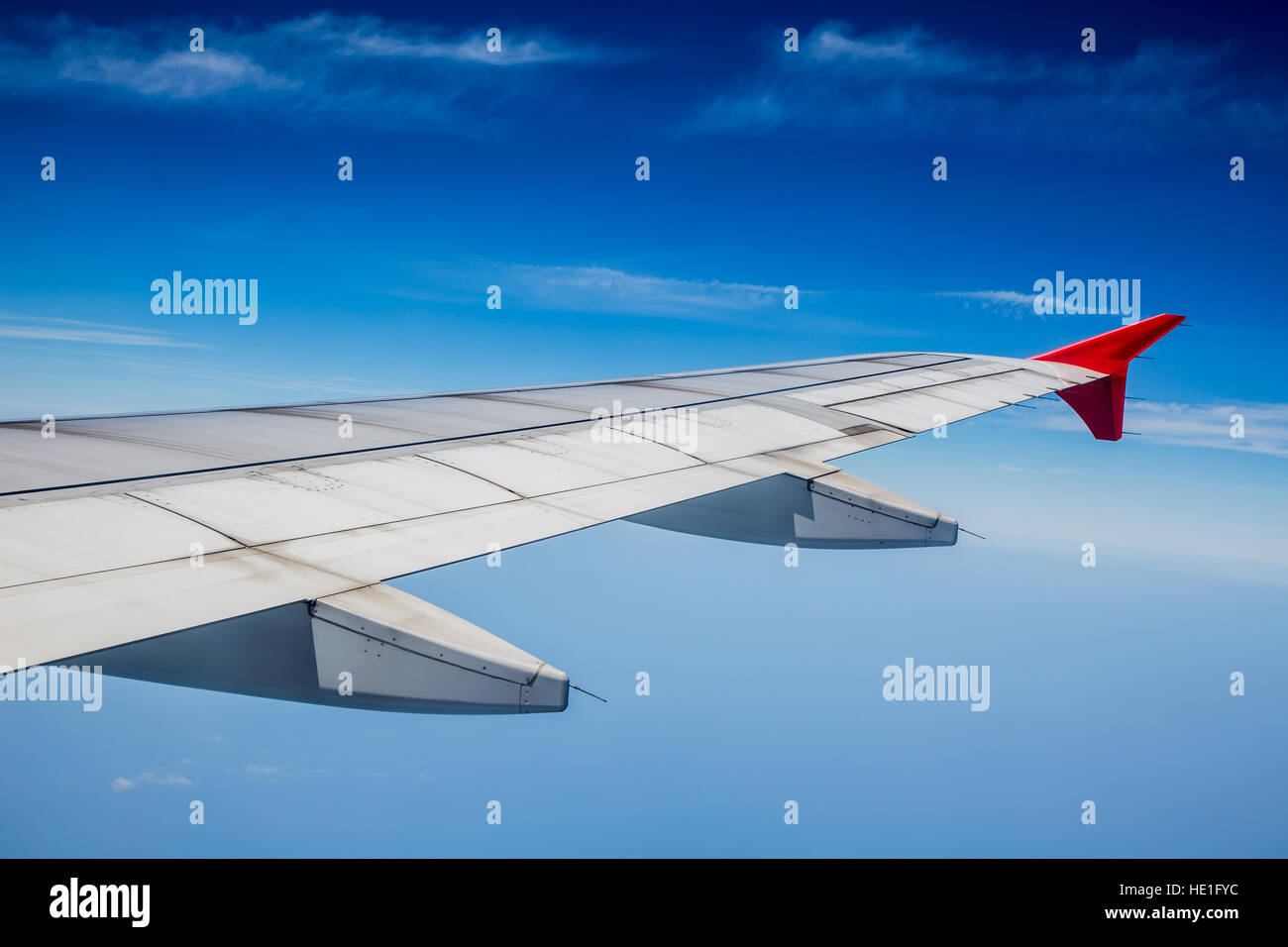 The right wing of airplane flying above the clouds in the blue sky ...