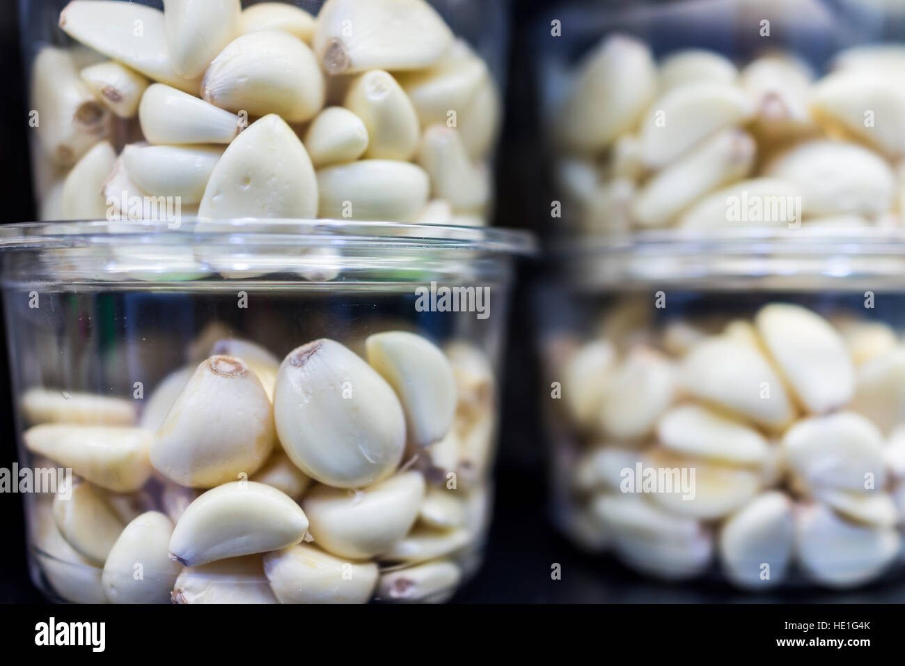 Closeup of plastic containers with peeled garlic Stock Photo - Alamy