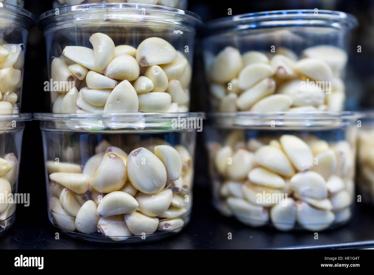 Closeup of plastic containers with peeled garlic Stock Photo - Alamy
