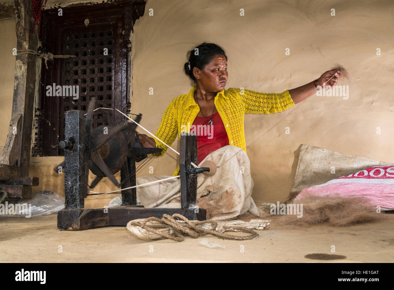 A local woman is spinning sheep wool with a traditional spinning wheel ...
