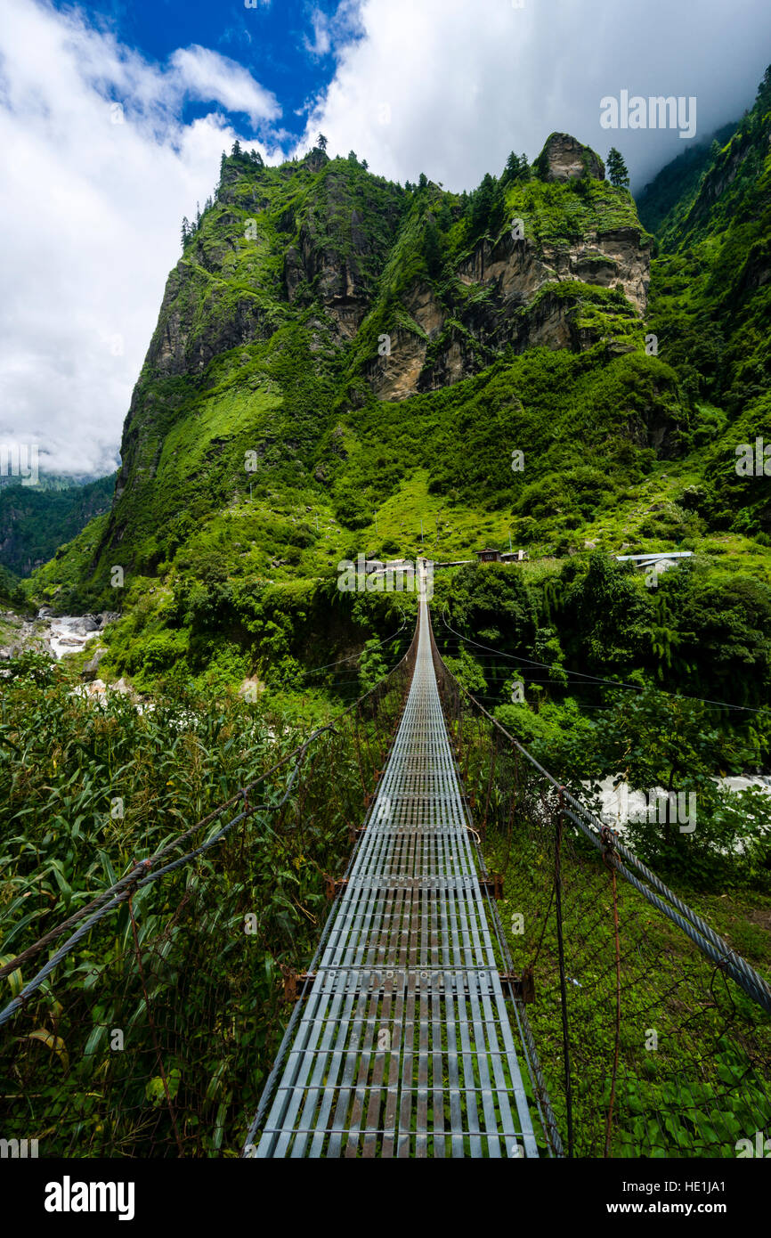 A steel suspension bridge is crossing the Marsyangdi river Stock Photo ...