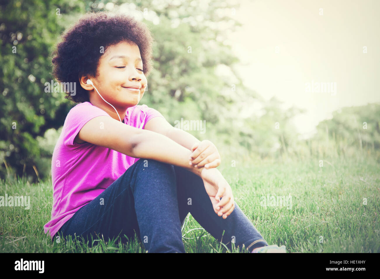 Little kid enjoying and listening to music in green park Stock Photo ...