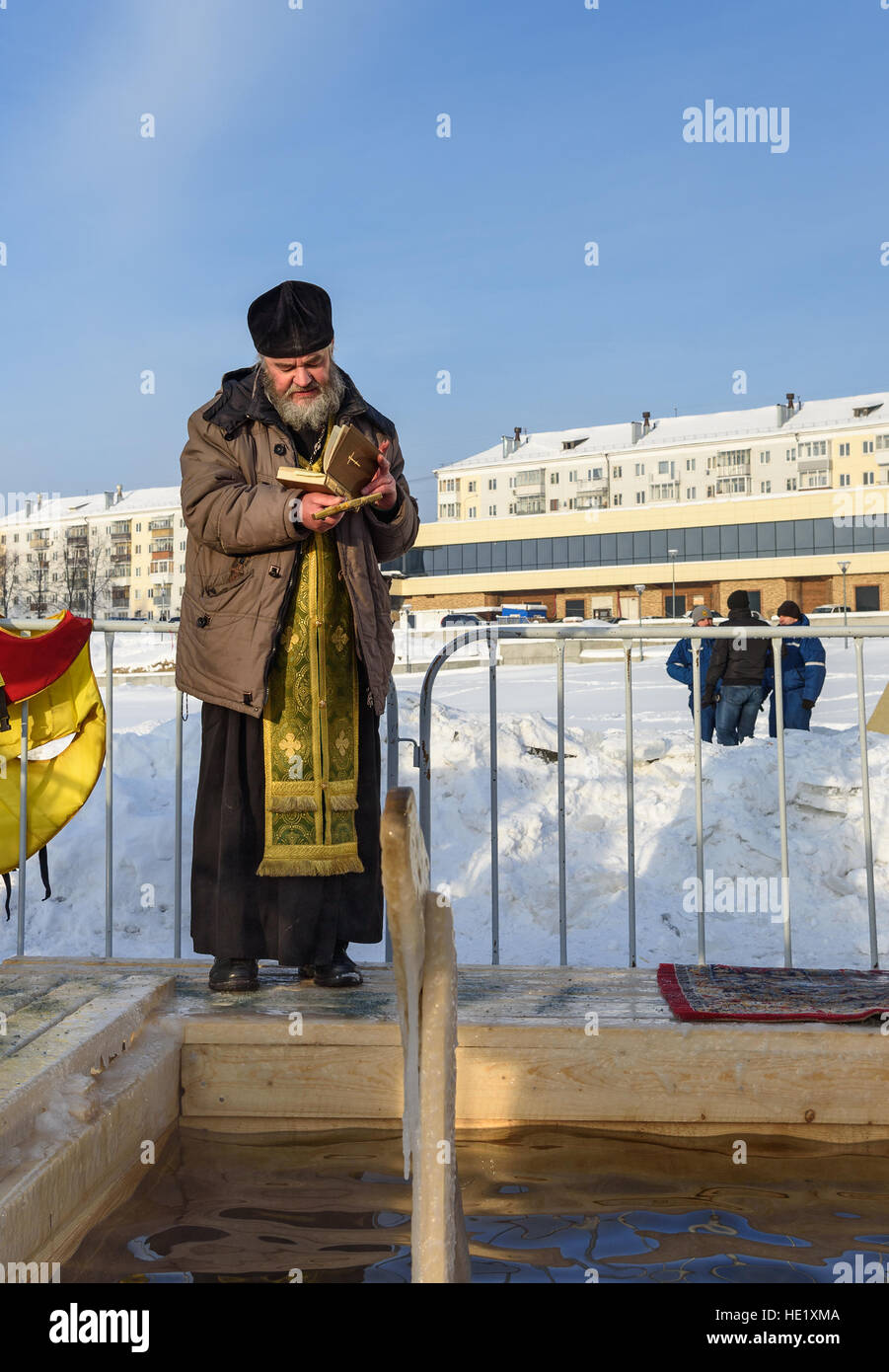 Priest consecrates the ice hole on Epiphany day. Traditional ice ...