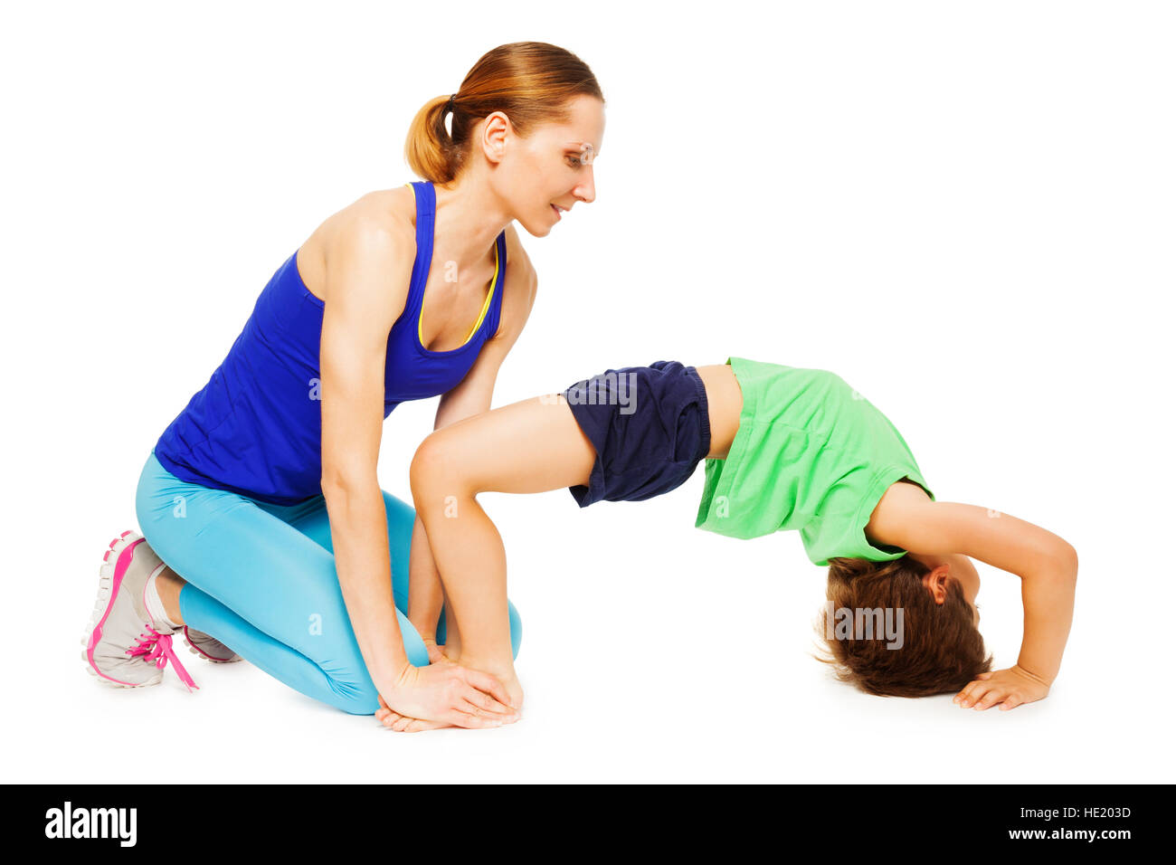 Female trainer teaching kid boy making a crab pose Stock Photo - Alamy