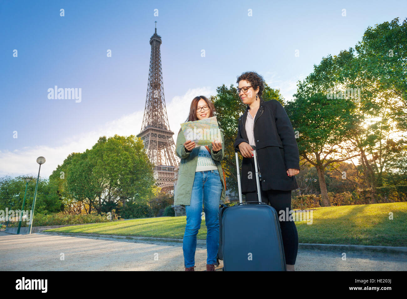Travelers reading map against the Eiffel Tower Stock Photo - Alamy