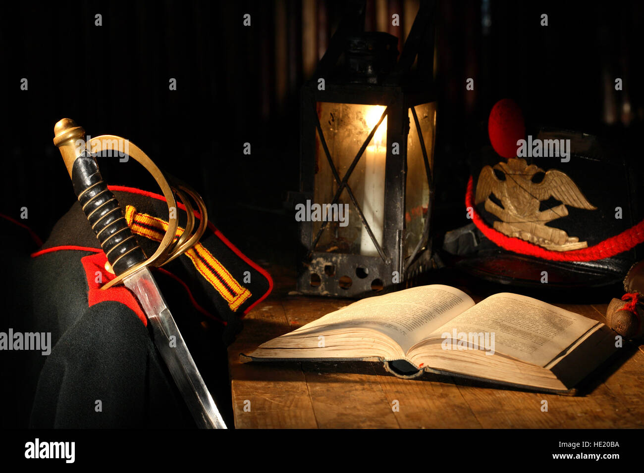 Vintage still life with ancient sword and military uniform near table ...