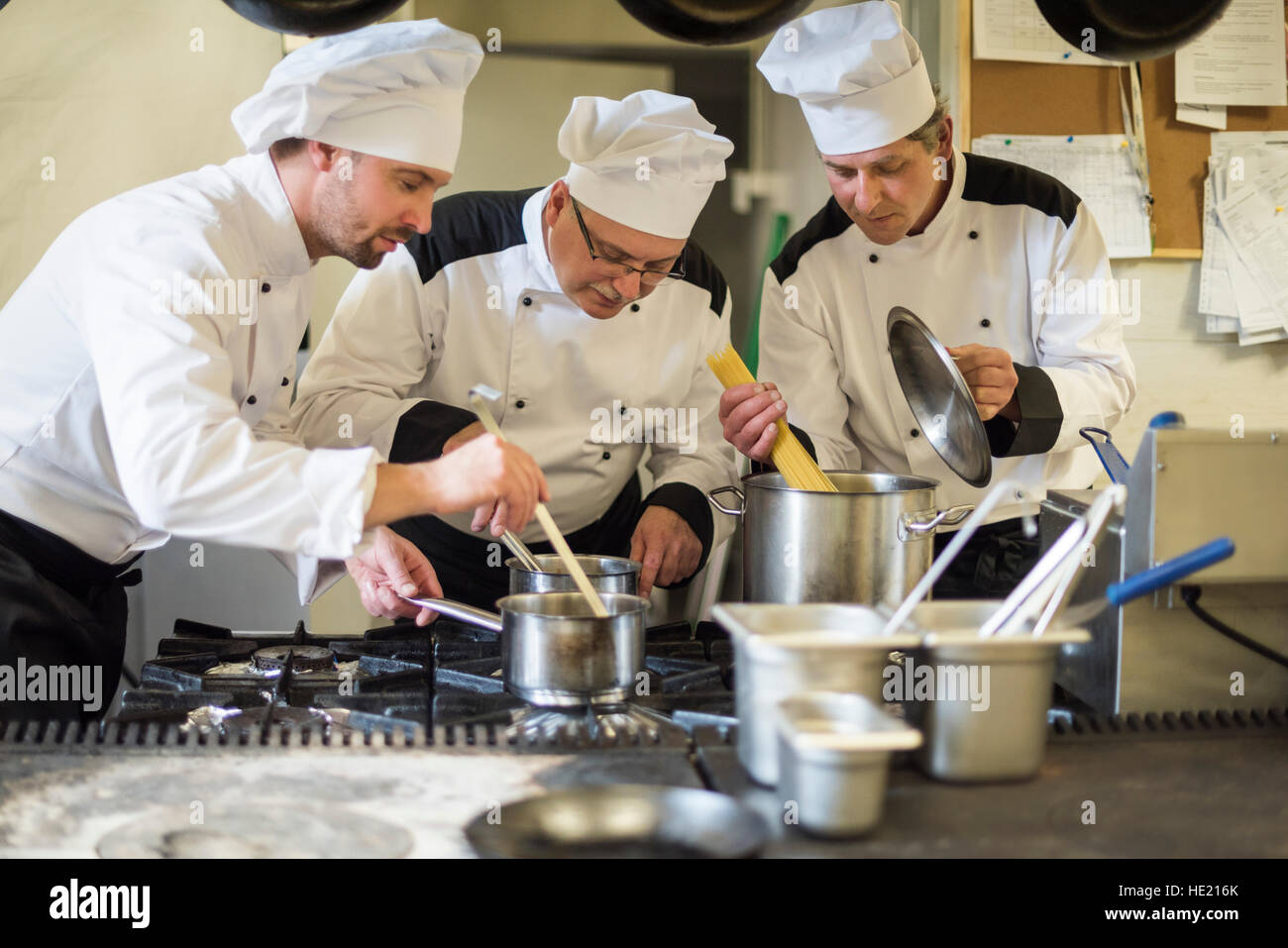 Three men busy in the commercial kitchen Stock Photo - Alamy