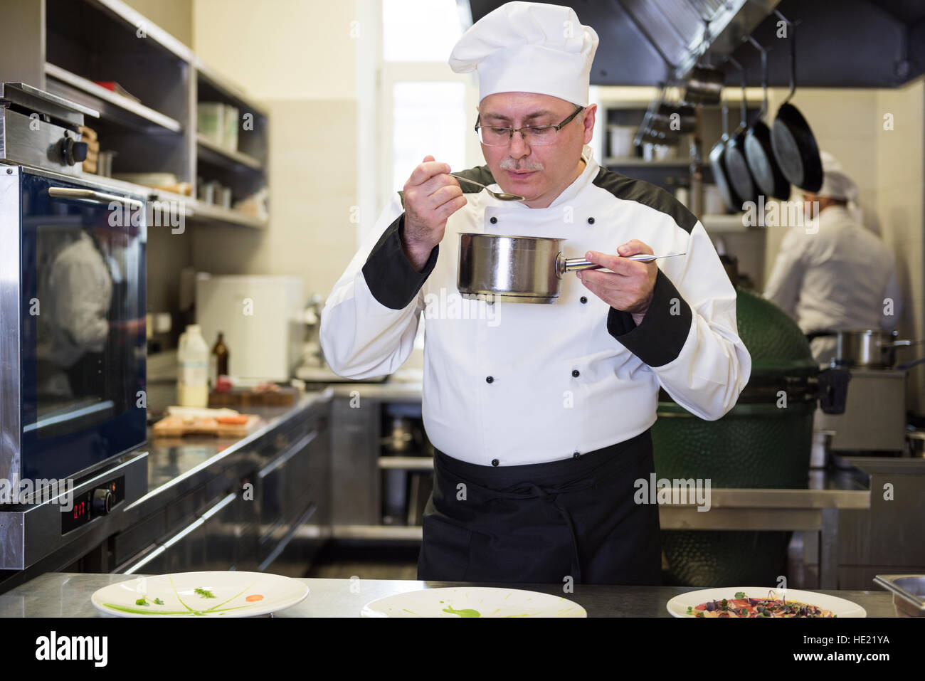 Chef sampling one of his meals Stock Photo - Alamy